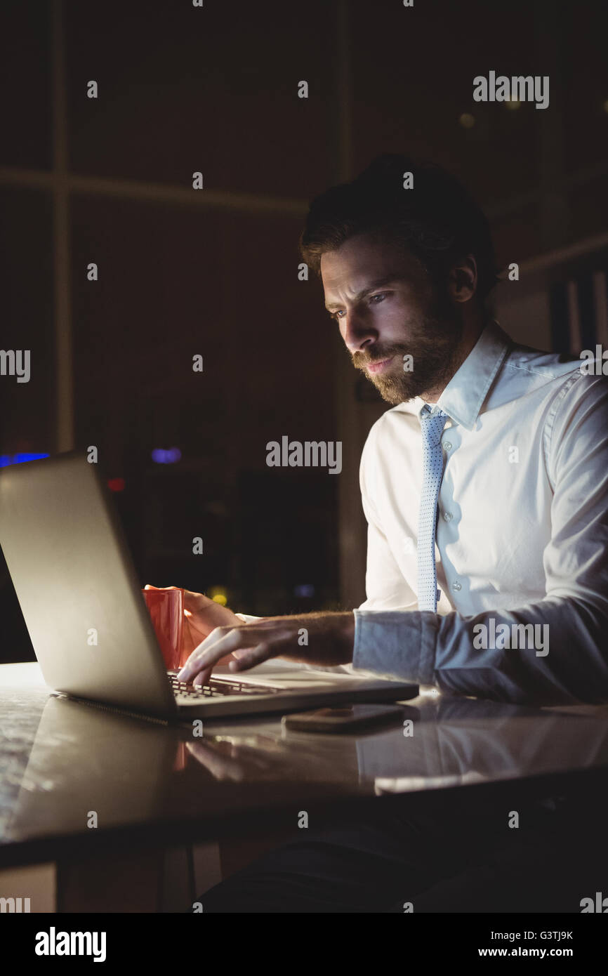 Businessman using laptop at night Stock Photo - Alamy