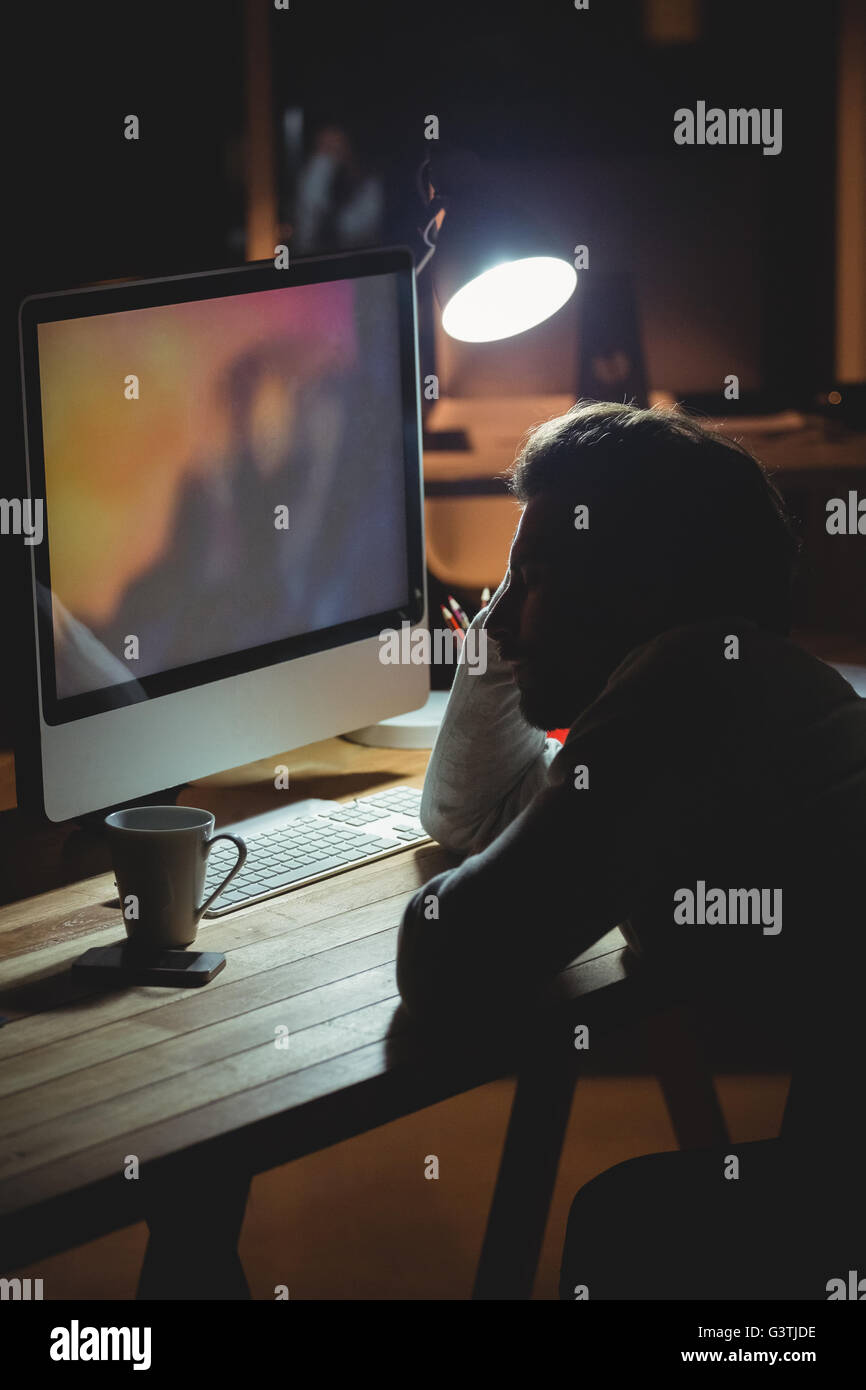 Sleepy businessman watching his computer Stock Photo - Alamy