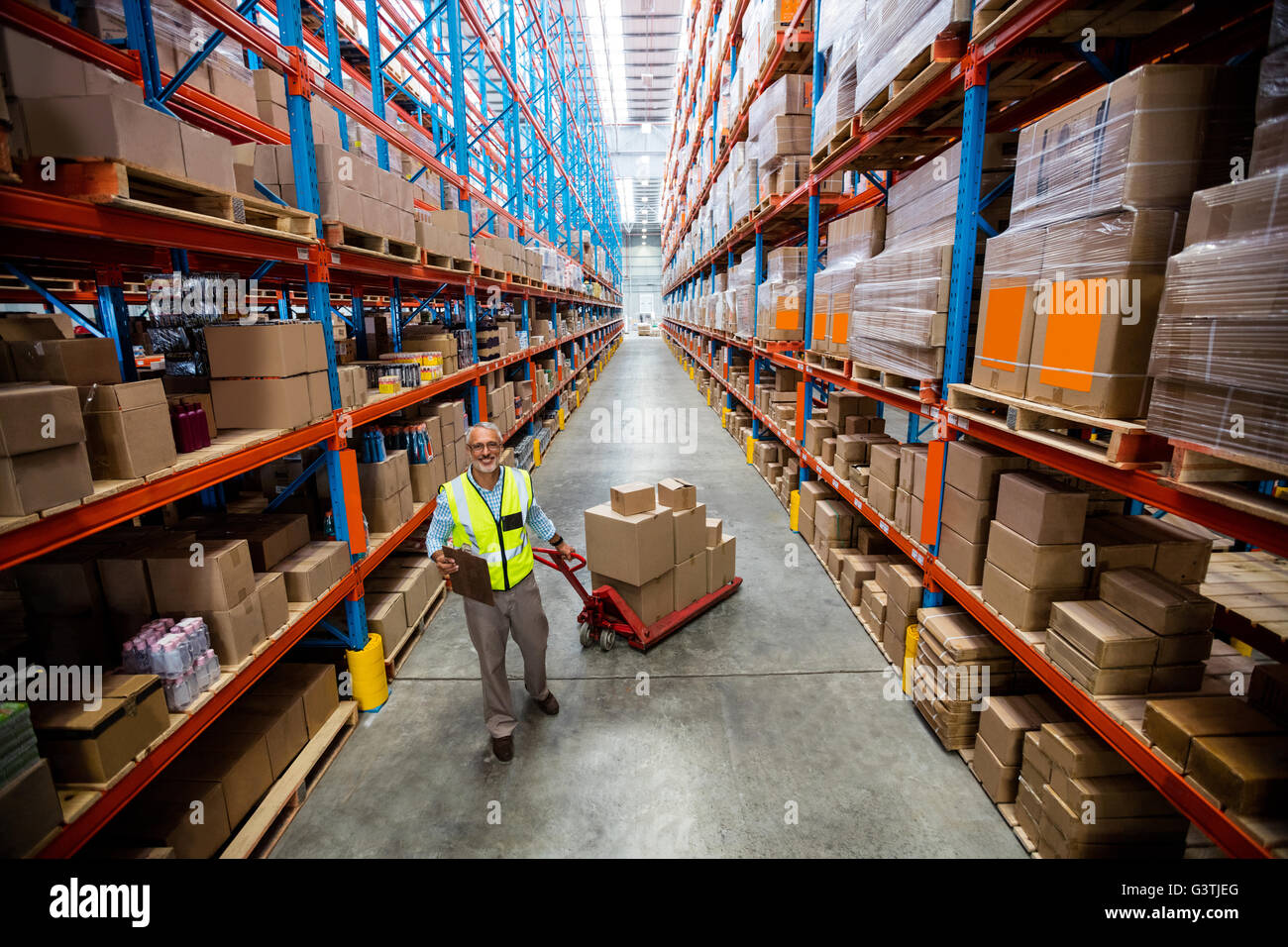 Warehouse worker pulling a warehouse isle Stock Photo - Alamy