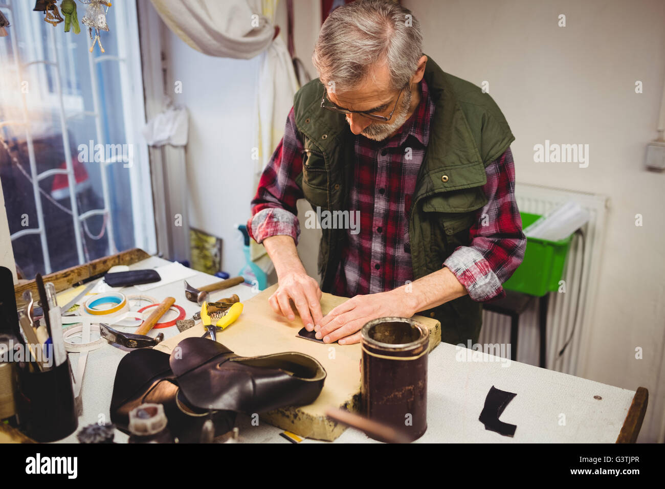 Cobbler pressing his hands against the material Stock Photo - Alamy