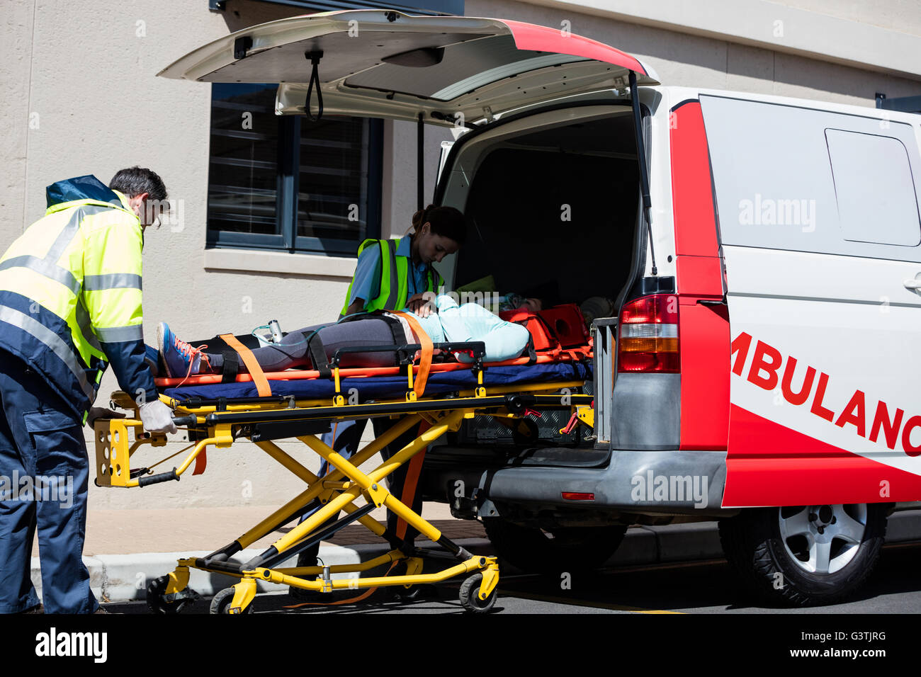Ambulance men bringing injured people inside ambulance car Stock Photo ...
