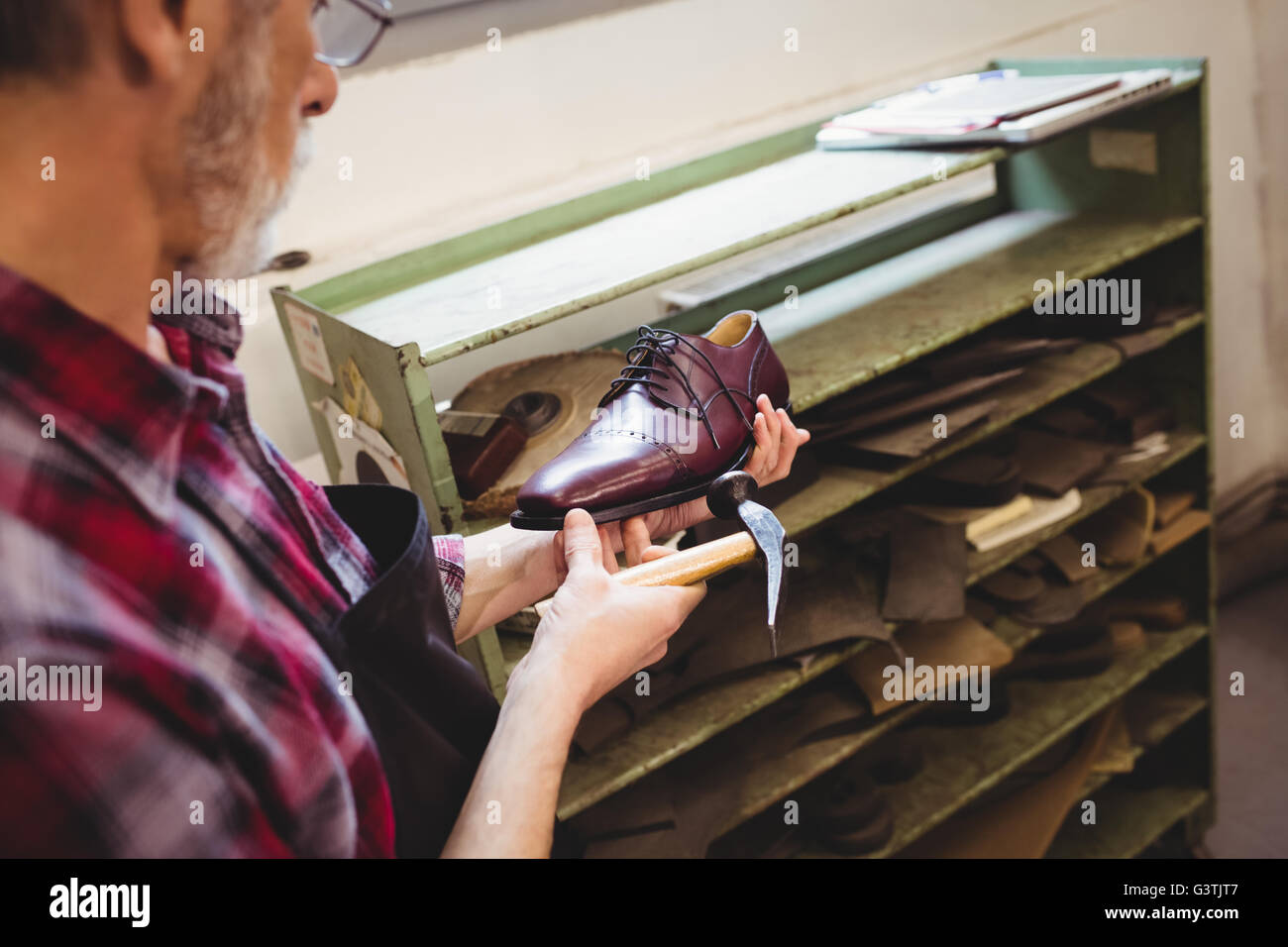 Rear view of cobbler making a shoe Stock Photo - Alamy