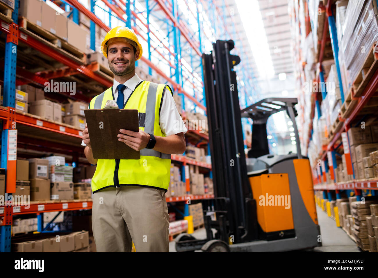 Smiling warehouse manager with clipboard Stock Photo - Alamy