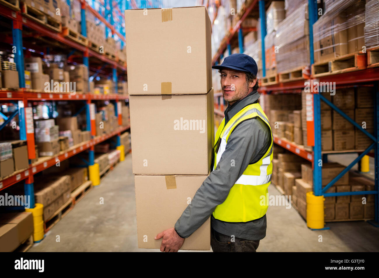 Warehouse worker carrying boxes Stock Photo - Alamy