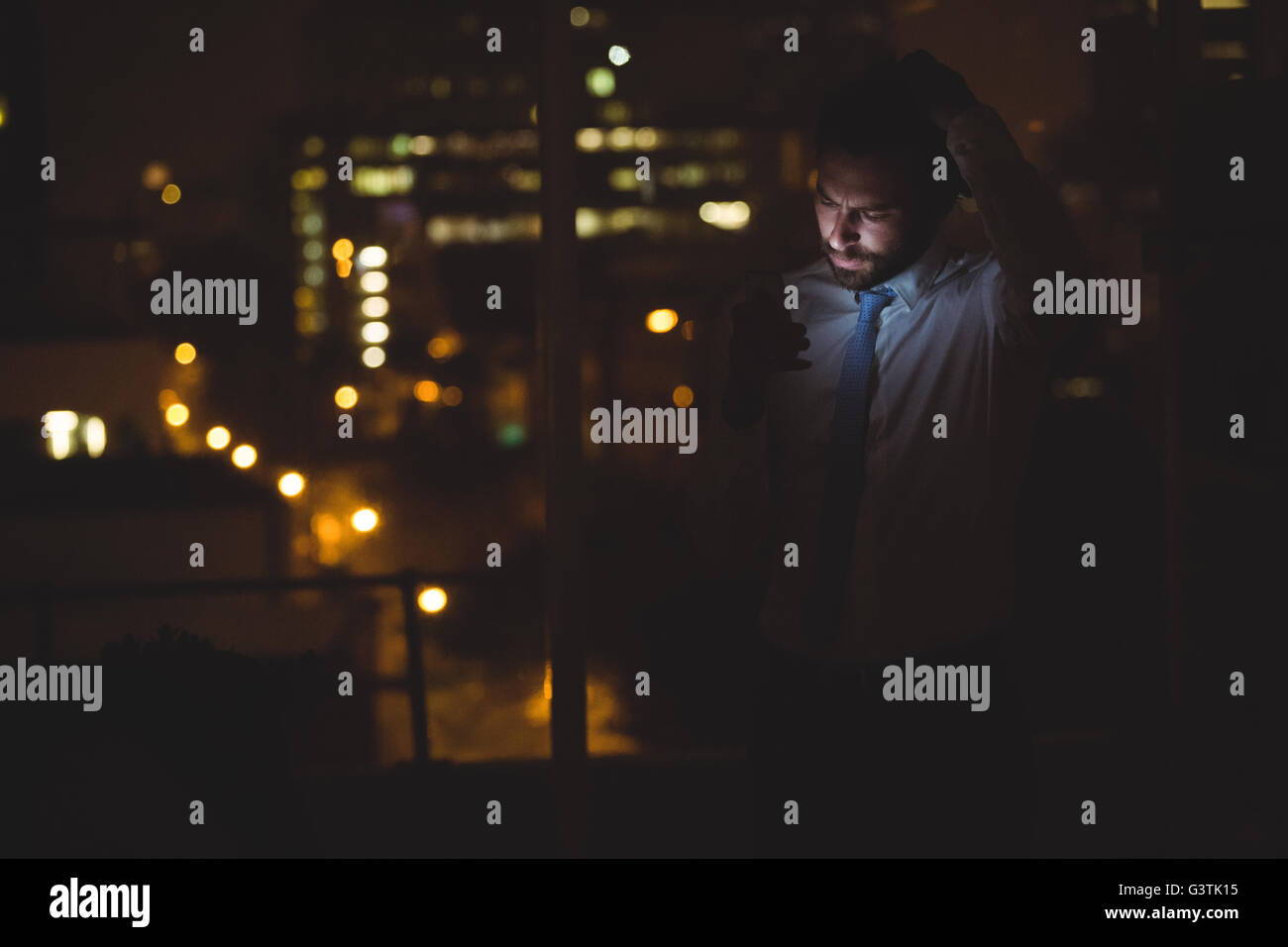 Businessman using smartphone at night Stock Photo - Alamy