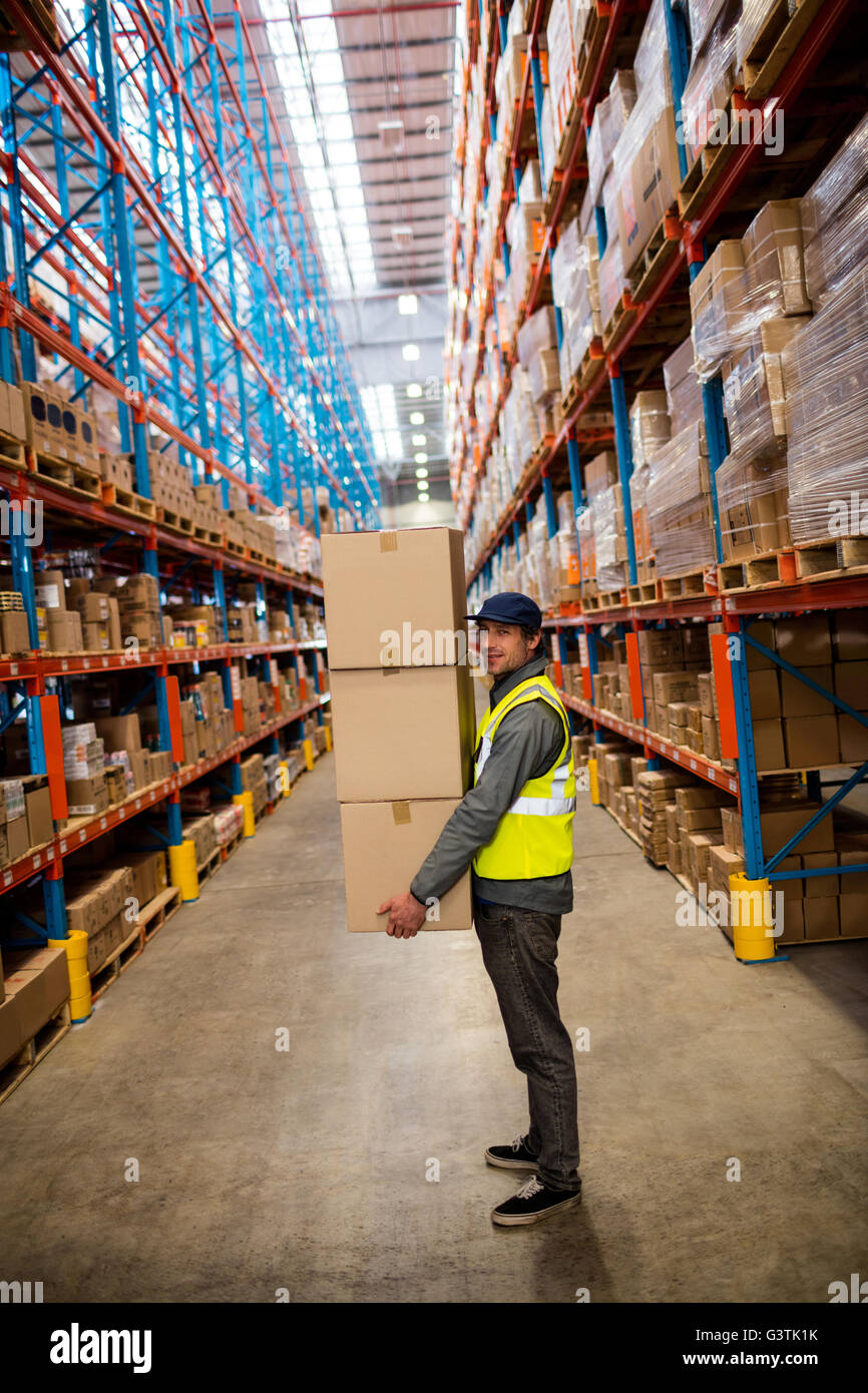 Warehouse worker carrying boxes Stock Photo - Alamy