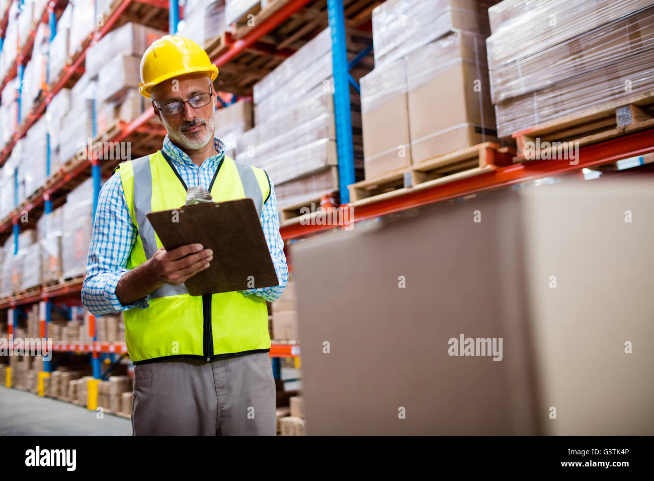 Warehouse worker reading its clipboard Stock Photo - Alamy