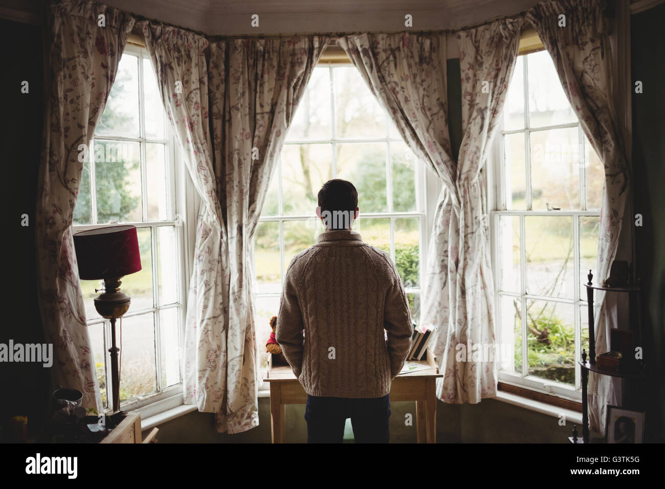 Rear view of hipster man looking through window Stock Photo - Alamy