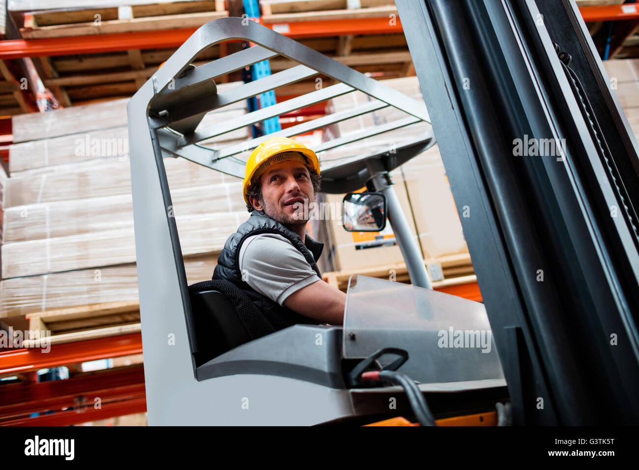Warehouse worker driving forklift Stock Photo - Alamy