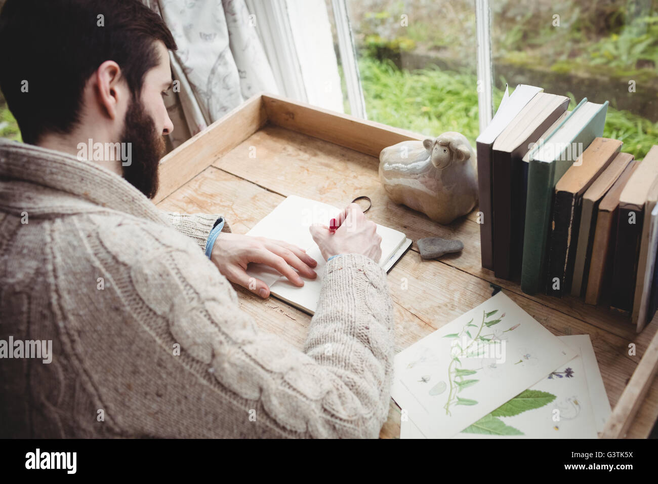 Attractive hipster man drawing at desk Stock Photo - Alamy