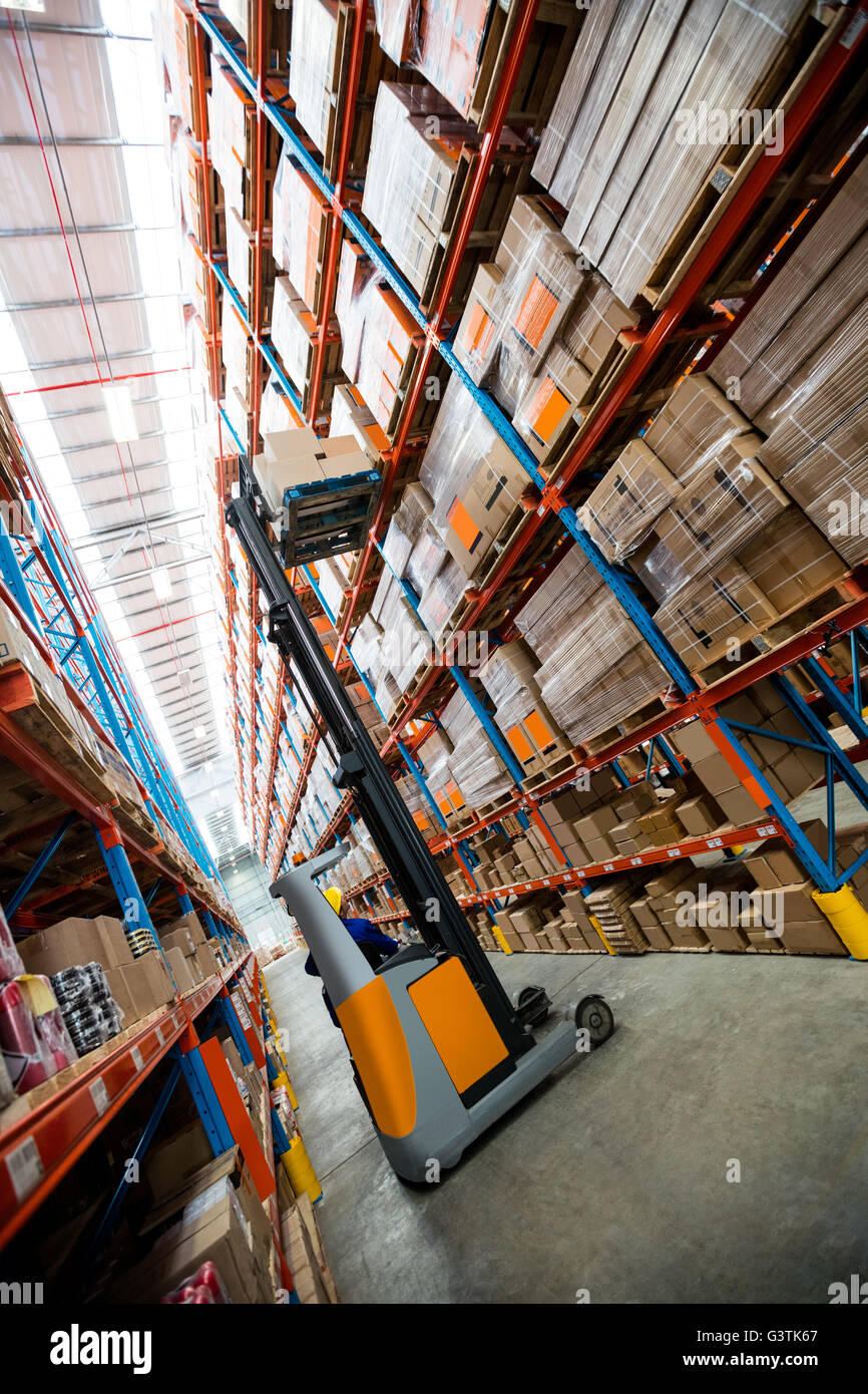 Warehouse worker using forklift Stock Photo - Alamy