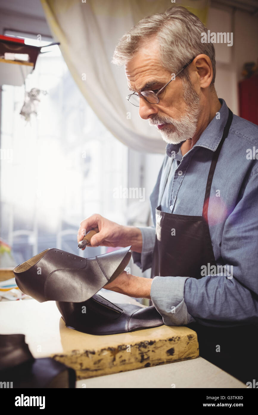 Profile view of cobbler making a shoe Stock Photo - Alamy