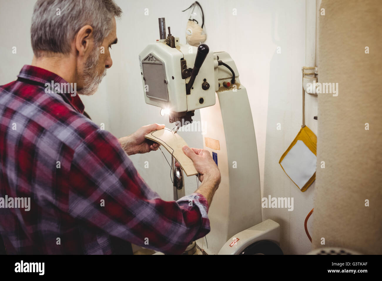 Side view of cobbler using a sewing machine Stock Photo - Alamy