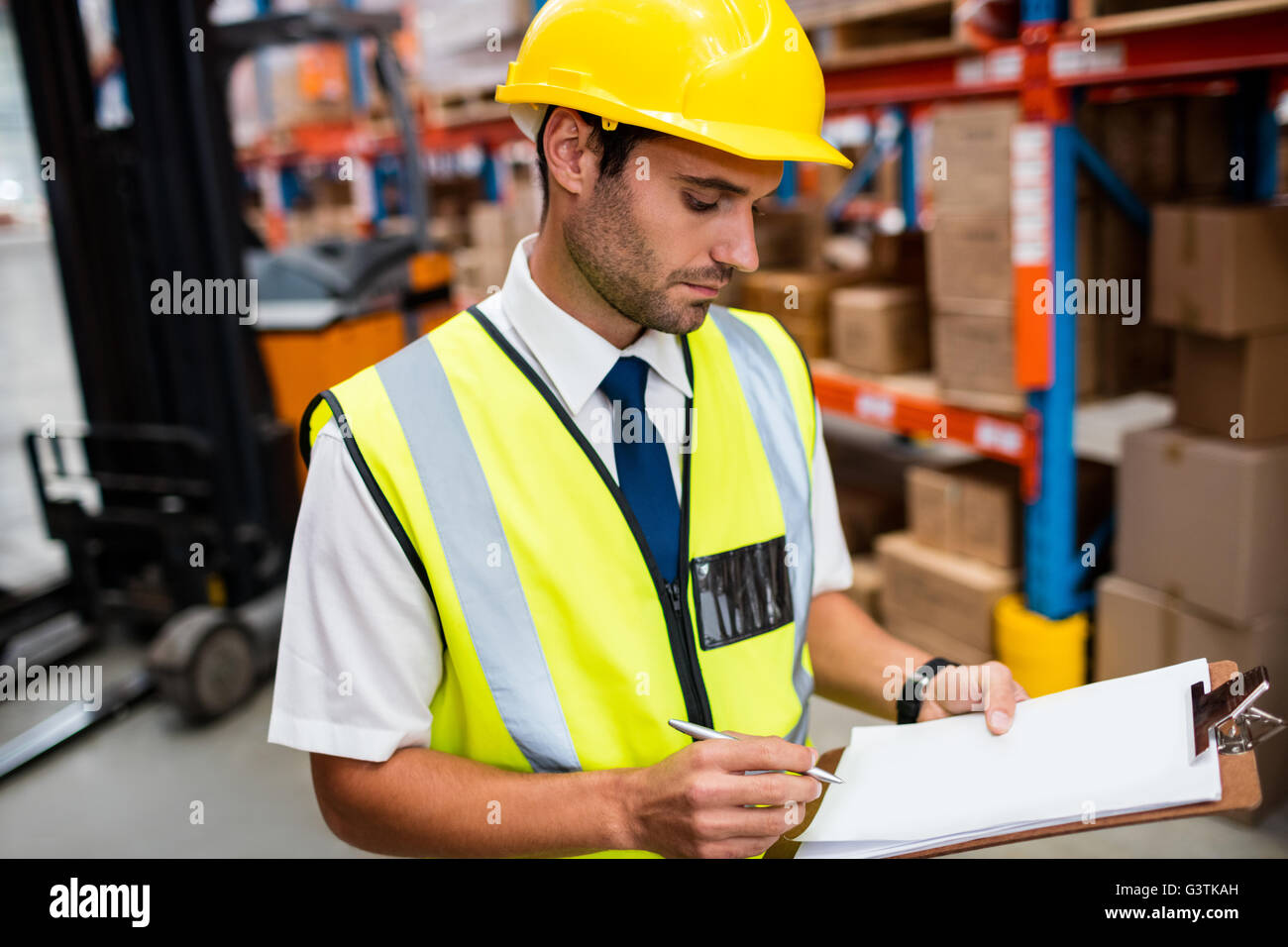Warehouse manager checking list on his clipboard Stock Photo - Alamy