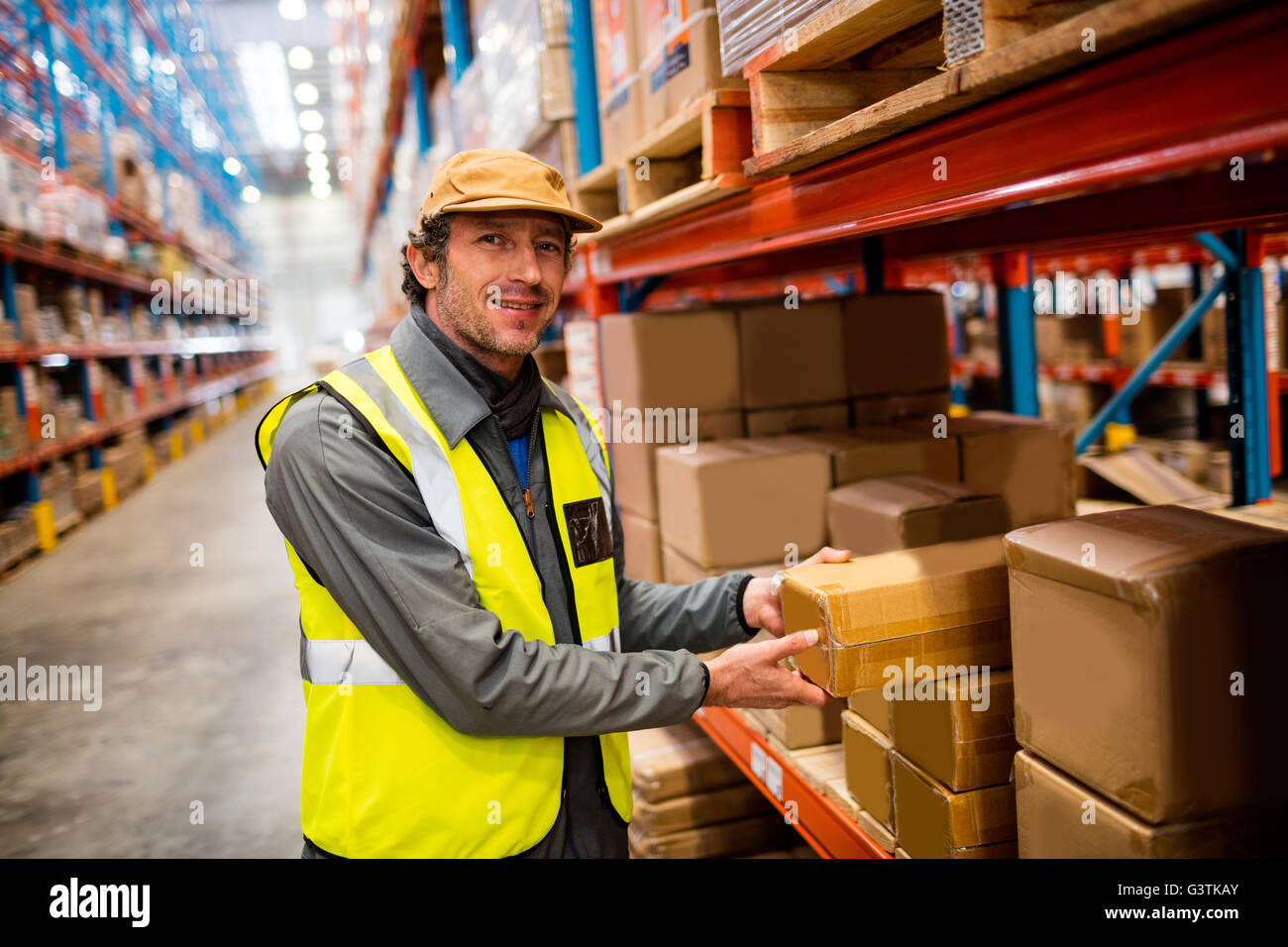 Warehouse worker taking package in the shelf Stock Photo - Alamy