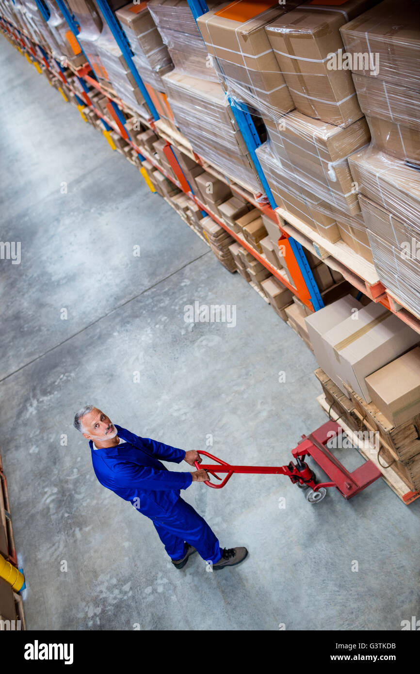 High angle view of man worker pulling the pallet truck Stock Photo - Alamy