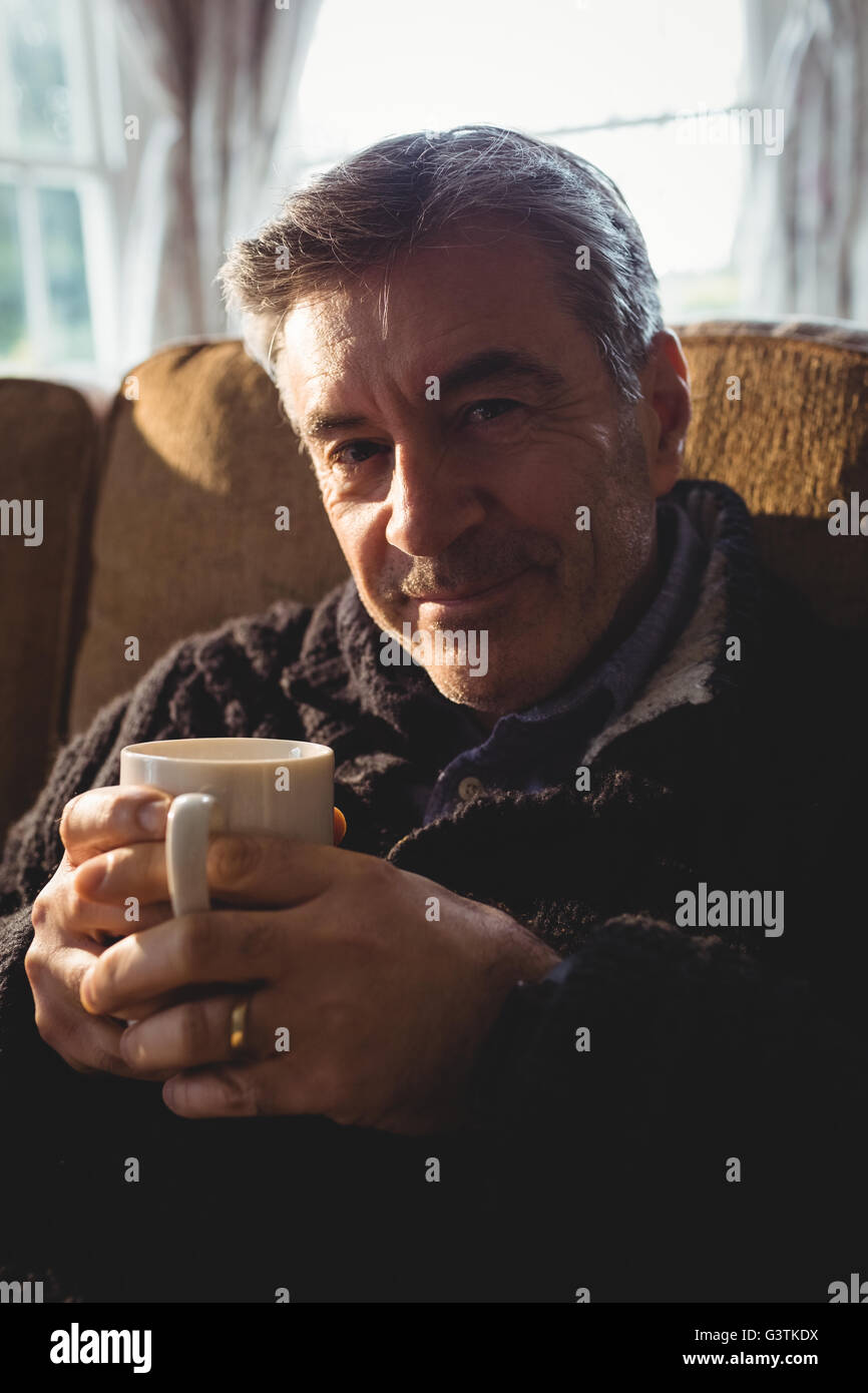 Portrait of man drinking cup of tea while relaxing Stock Photo - Alamy