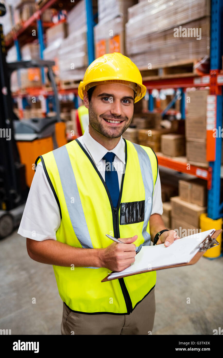 Smiling warehouse manager with clipboard Stock Photo - Alamy
