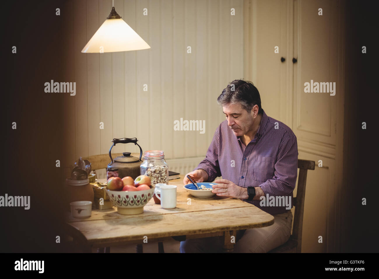 Mature man having breakfast alone Stock Photo - Alamy