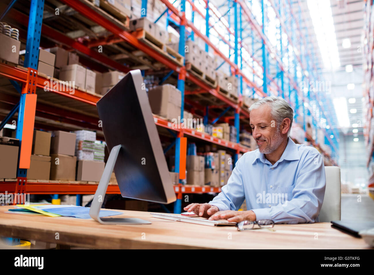 Warehouse manager using a laptop Stock Photo - Alamy