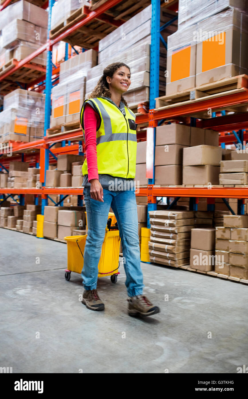 Happy woman pushing warehouse floor Stock Photo - Alamy