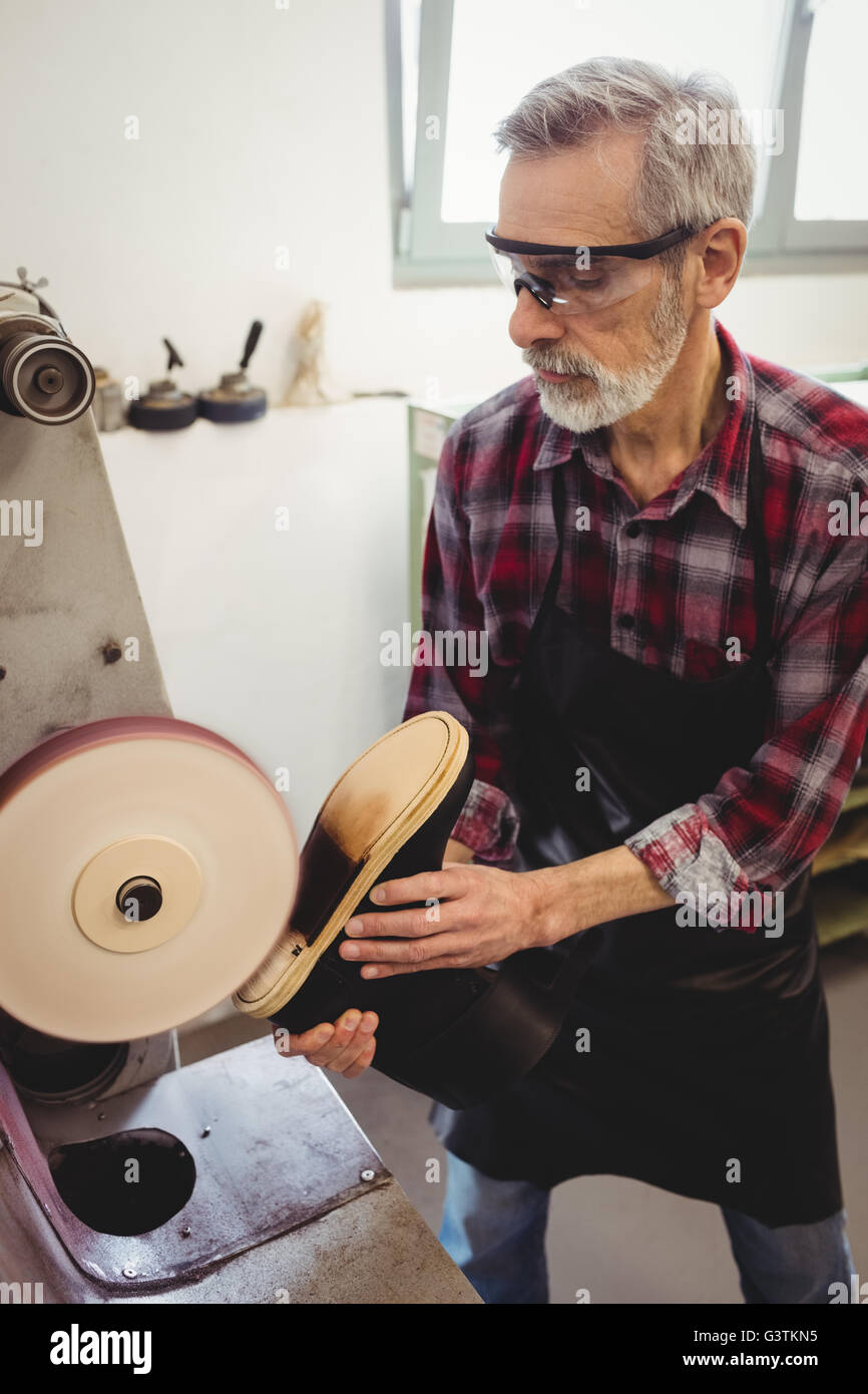 Side view of cobbler using a sander machine Stock Photo - Alamy