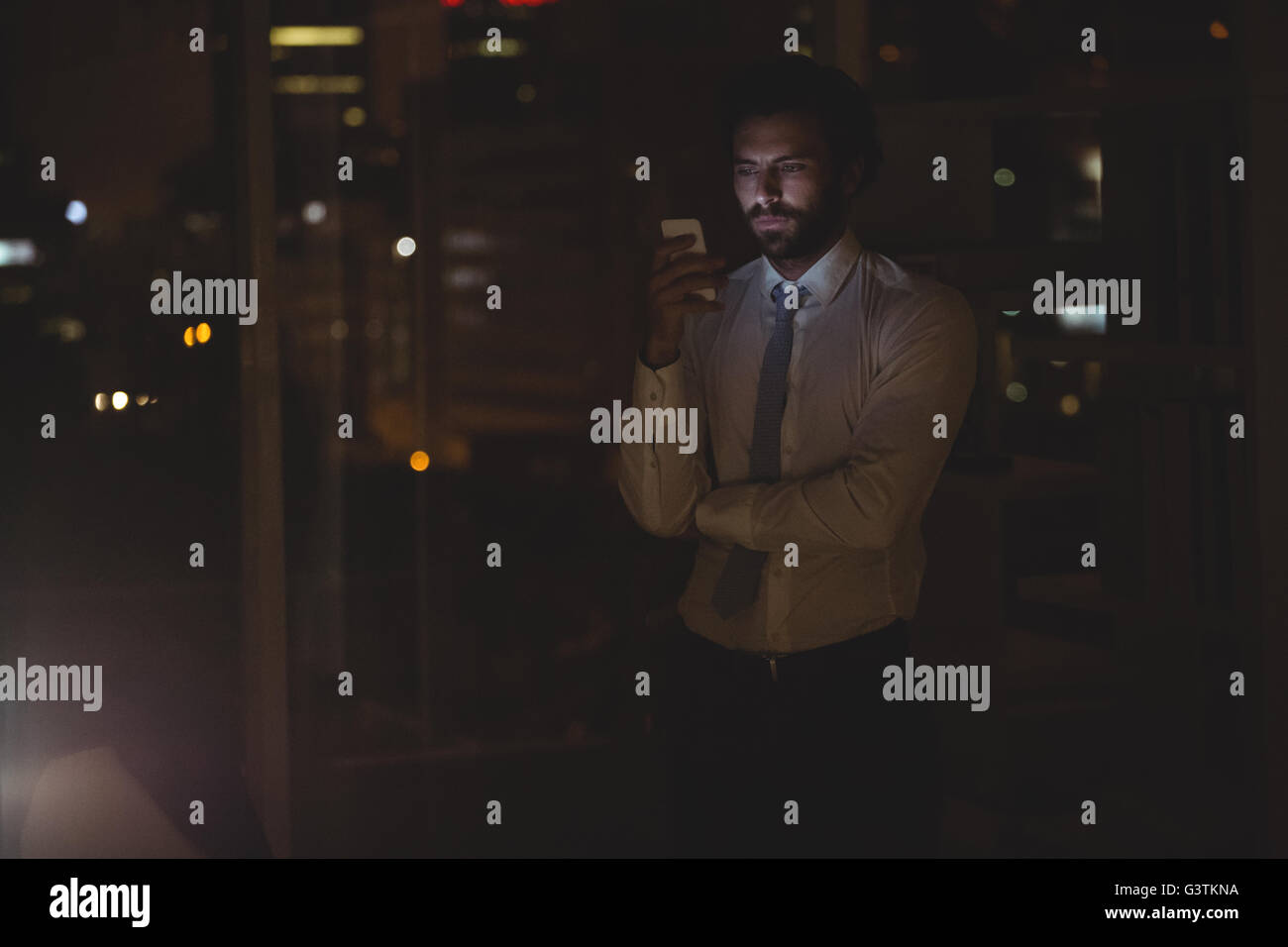 Businessman using smartphone at night Stock Photo - Alamy