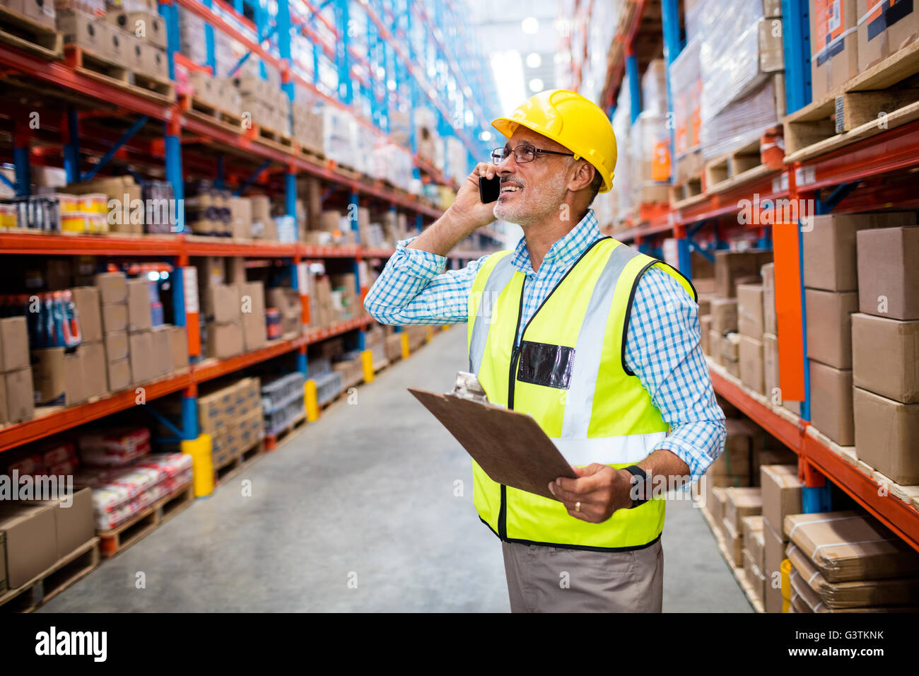 Warehouse worker on a phone call Stock Photo - Alamy