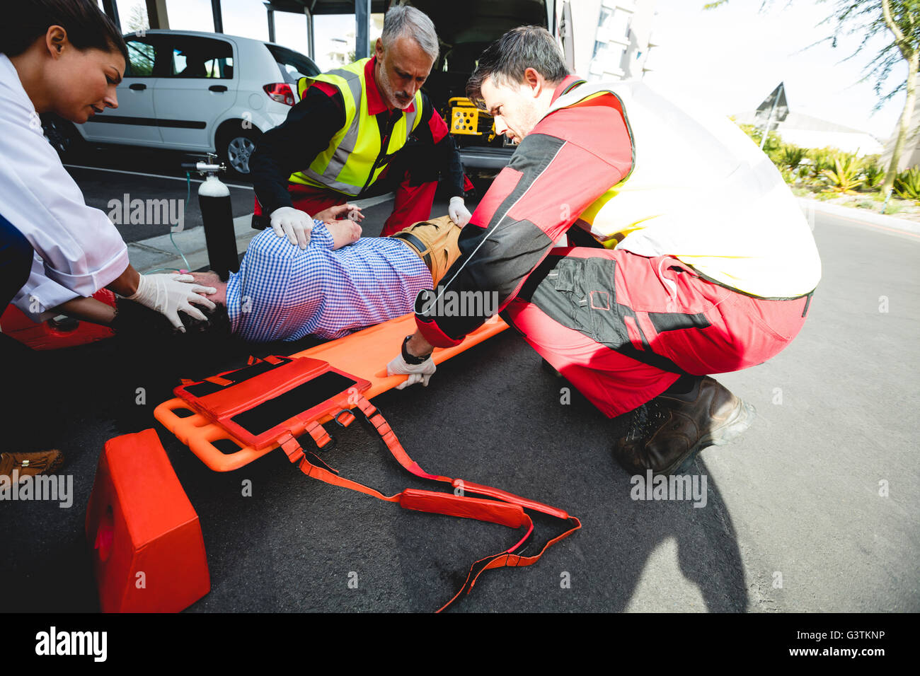 Injured man being healed by a team of ambulancemen Stock Photo - Alamy
