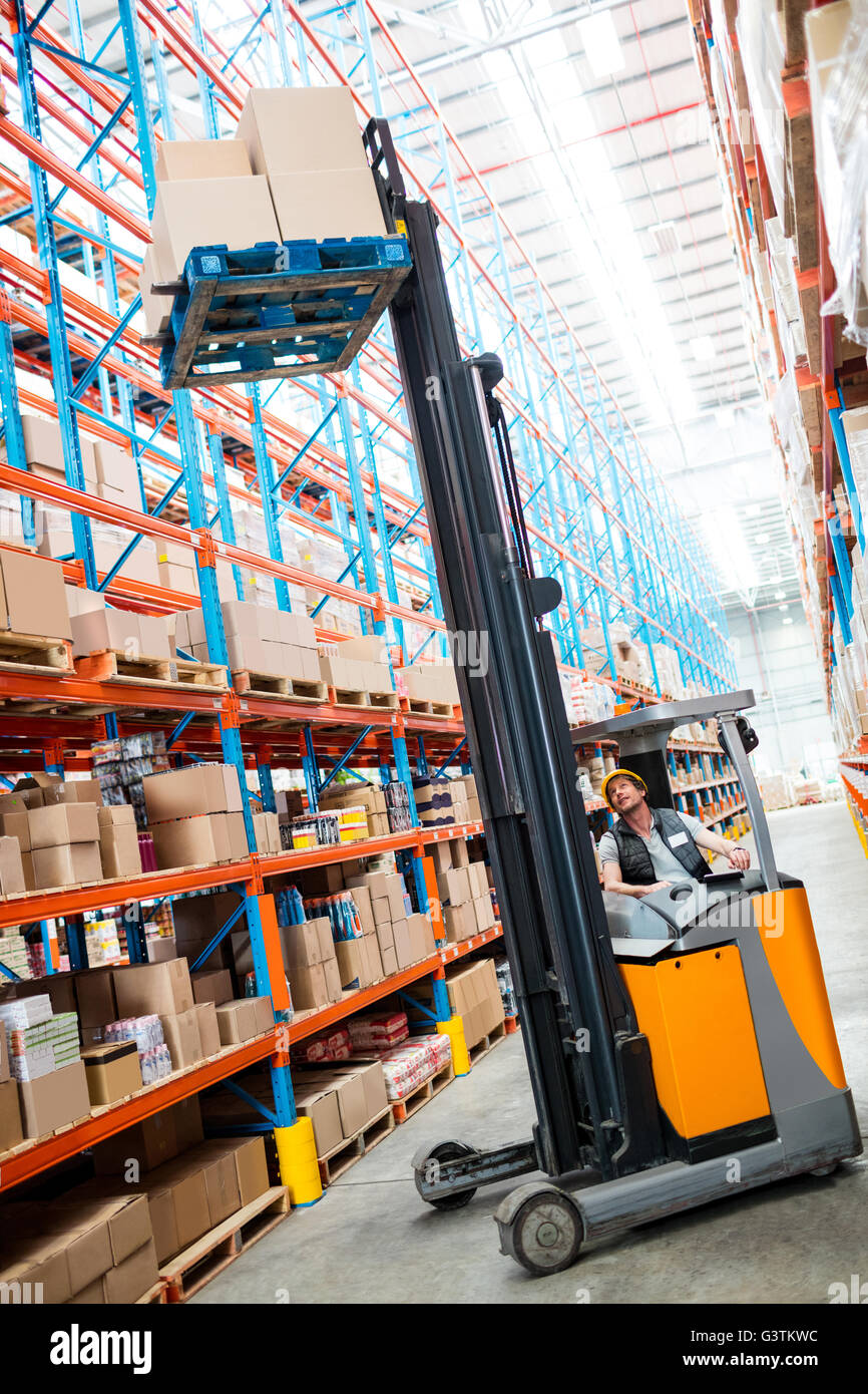 Warehouse worker using forklift Stock Photo - Alamy