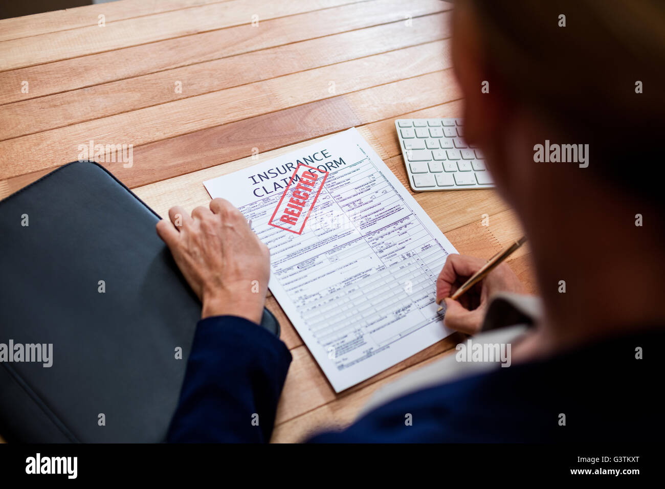 People writing on an insurance claim form Stock Photo - Alamy