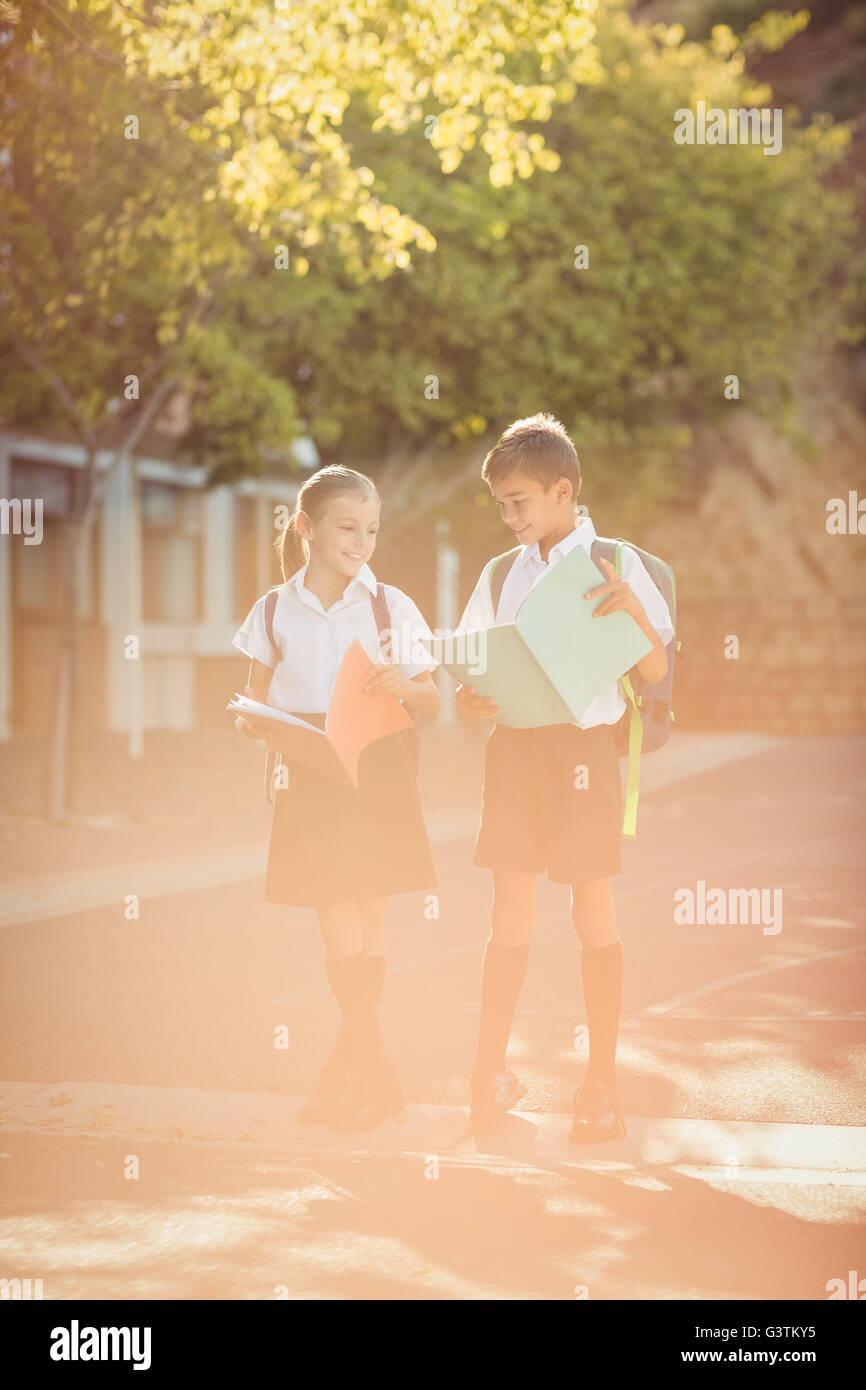 School kids reading books while walking in campus Stock Photo - Alamy
