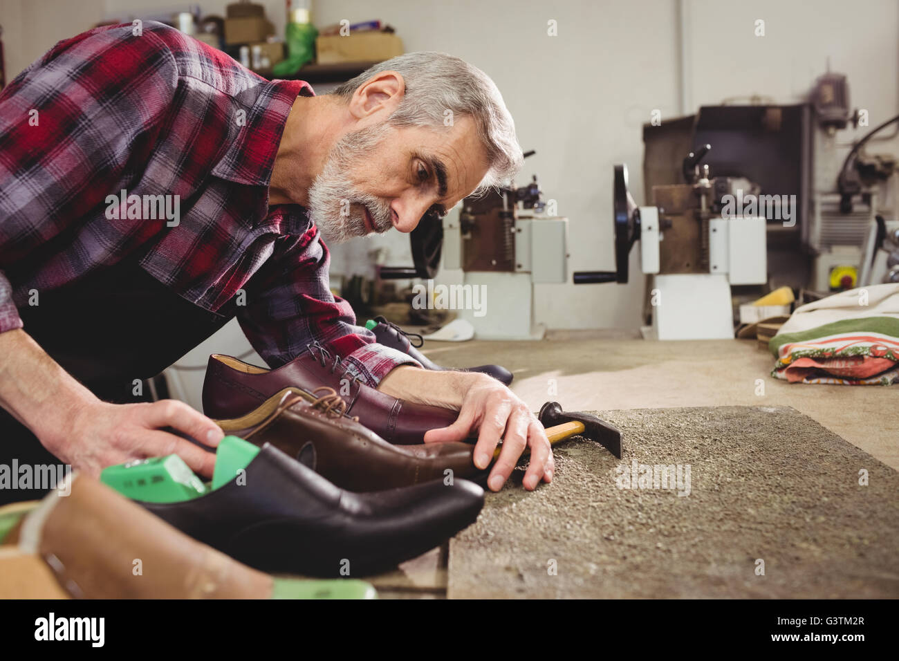 Cobbler examining a shoe Stock Photo - Alamy