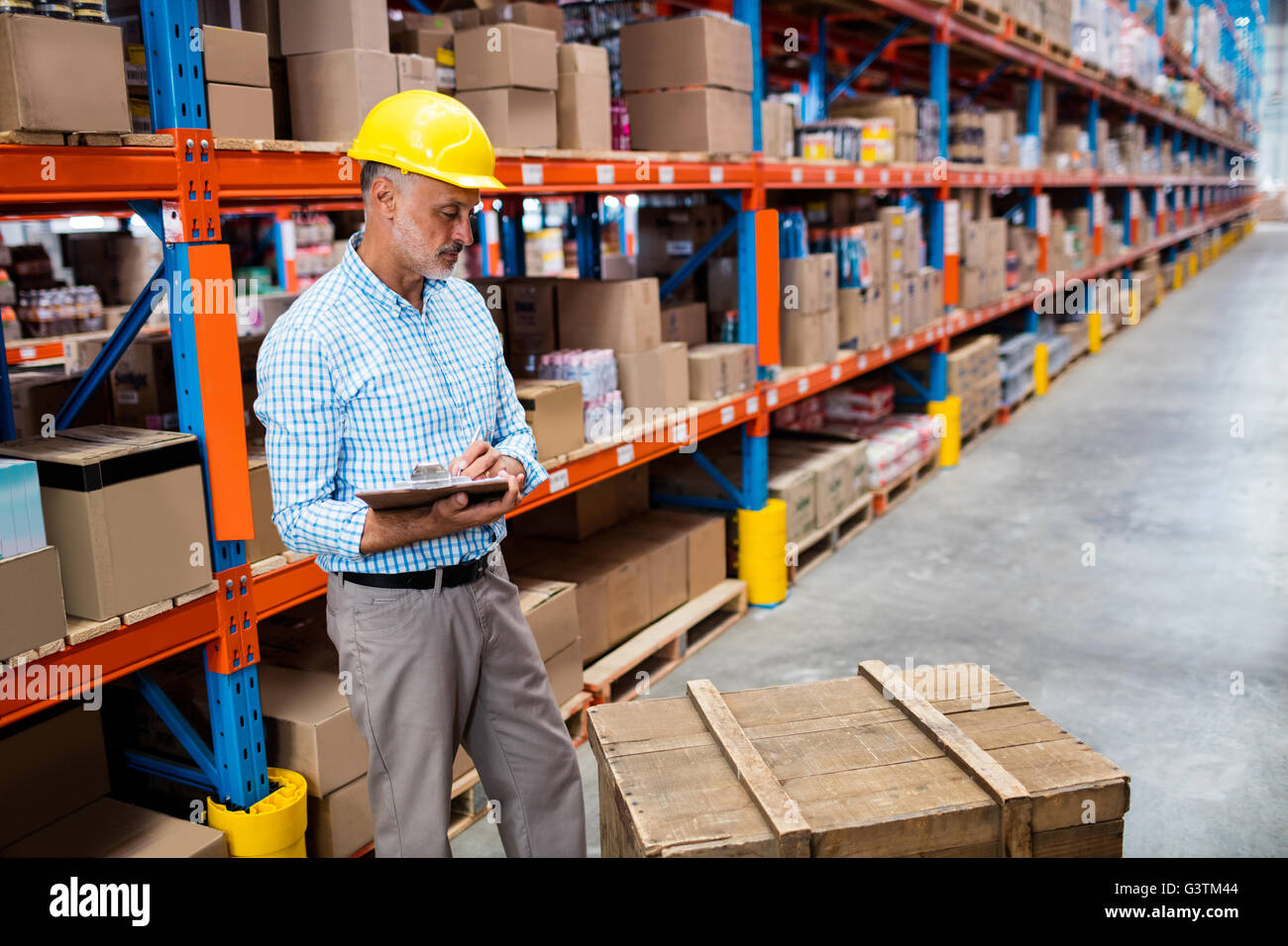 Warehouse worker checking his list on clipboard Stock Photo - Alamy
