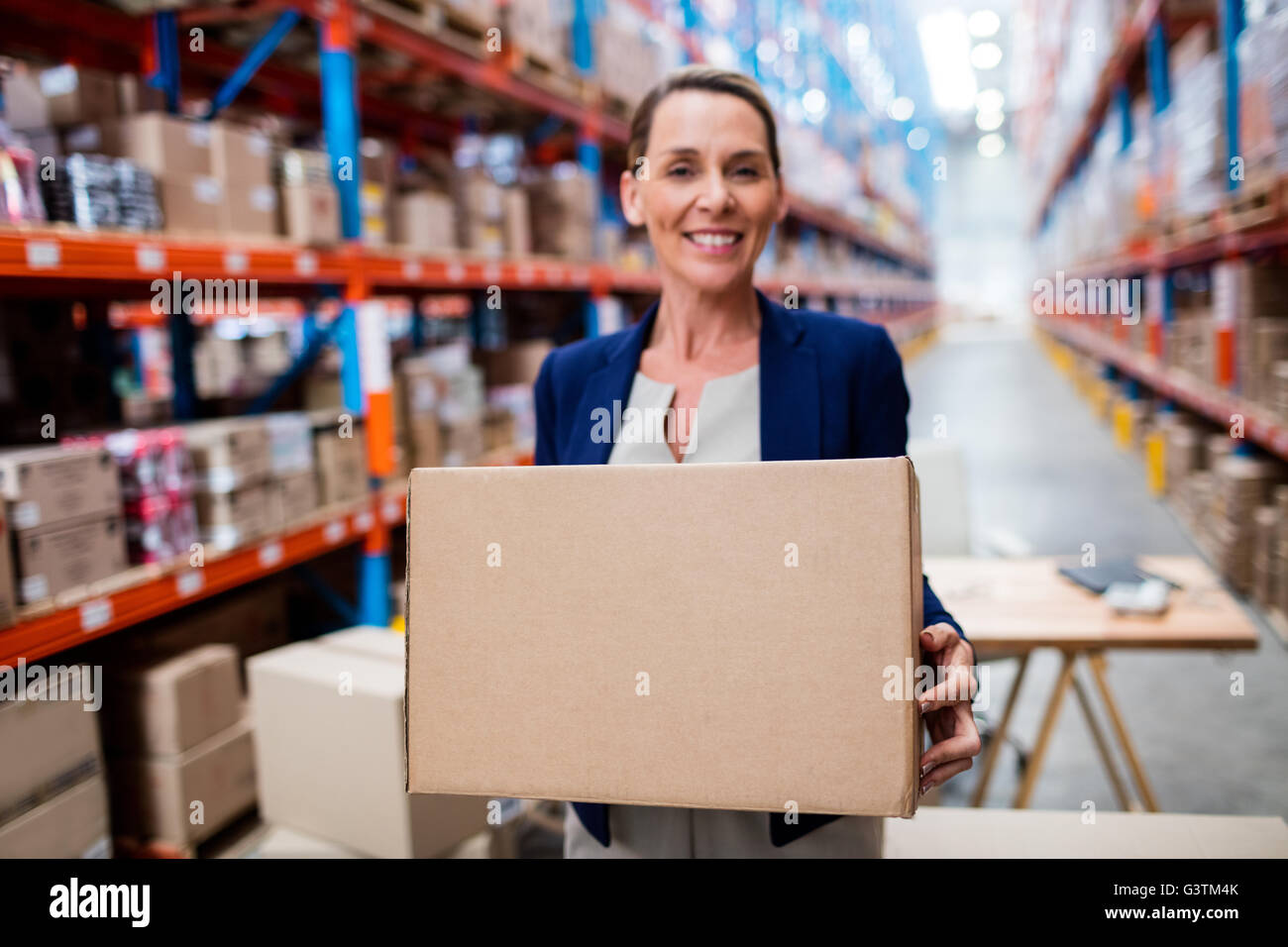 Warehouse manager holding a box Stock Photo - Alamy