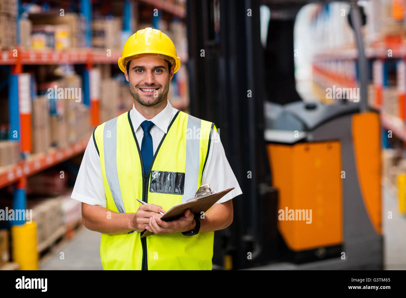 Smiling warehouse manager with clipboard Stock Photo - Alamy