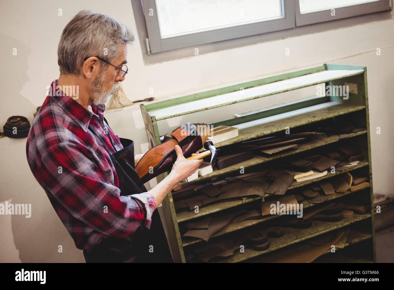 Profile view of cobbler making a shoe Stock Photo - Alamy