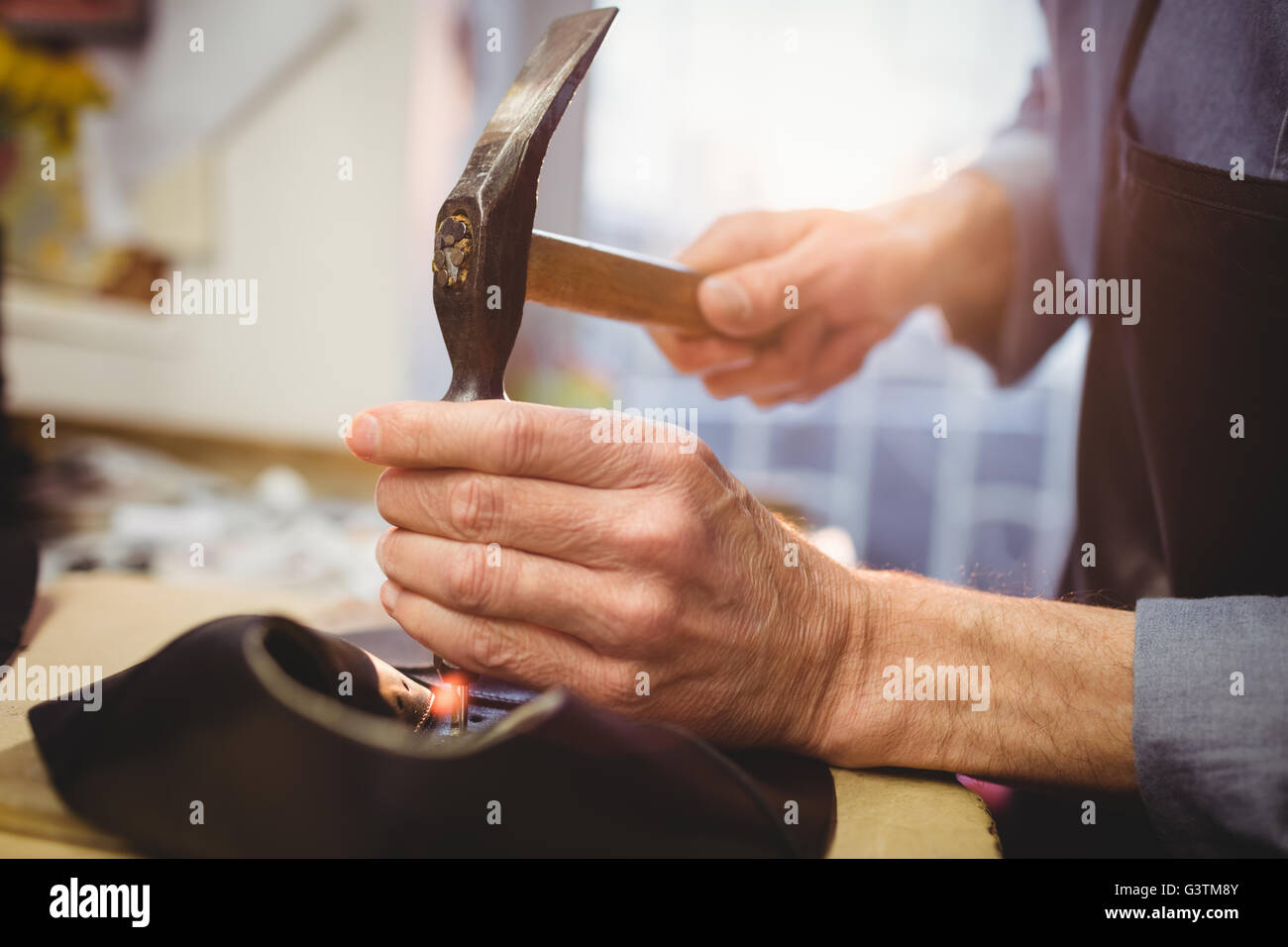 Side view of cobbler making a shoe with a hammer Stock Photo - Alamy