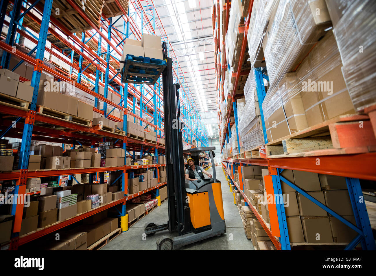Warehouse worker using forklift Stock Photo - Alamy