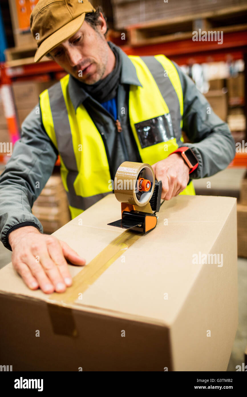 Man worker taping up a box Stock Photo - Alamy