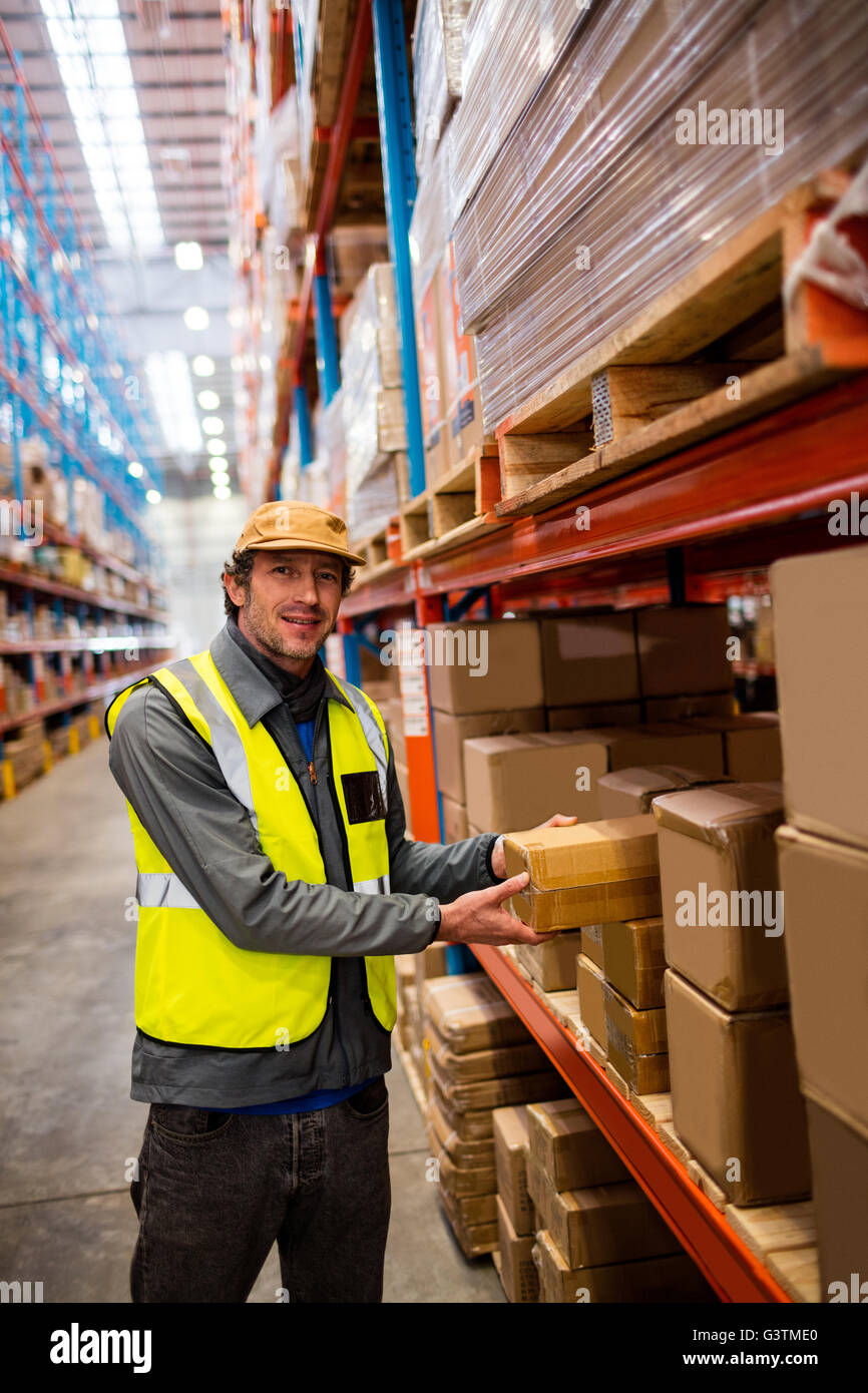 Warehouse worker taking package in the shelf Stock Photo - Alamy
