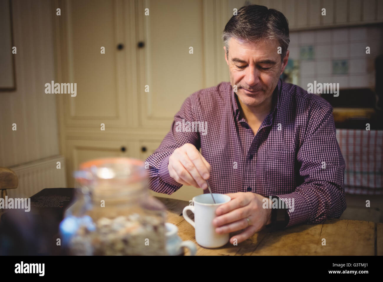 Mature man is mixing his drink Stock Photo - Alamy