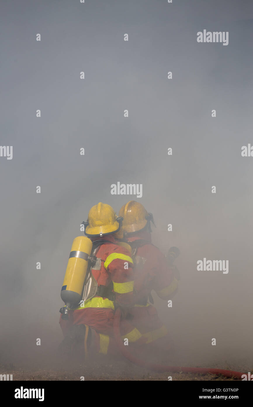 two firefighters is working surround with smoke Stock Photo - Alamy