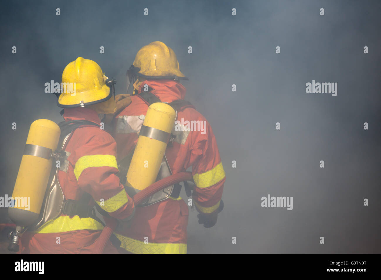 two firefighters is working surround with smoke and dust Stock Photo ...