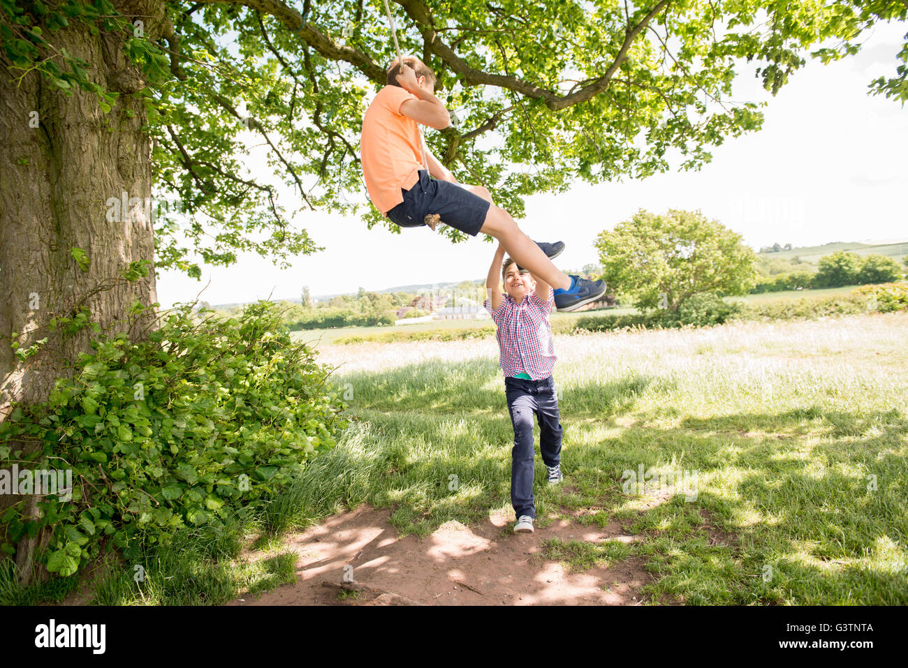 Two boys playing on swing hi-res stock photography and images - Alamy