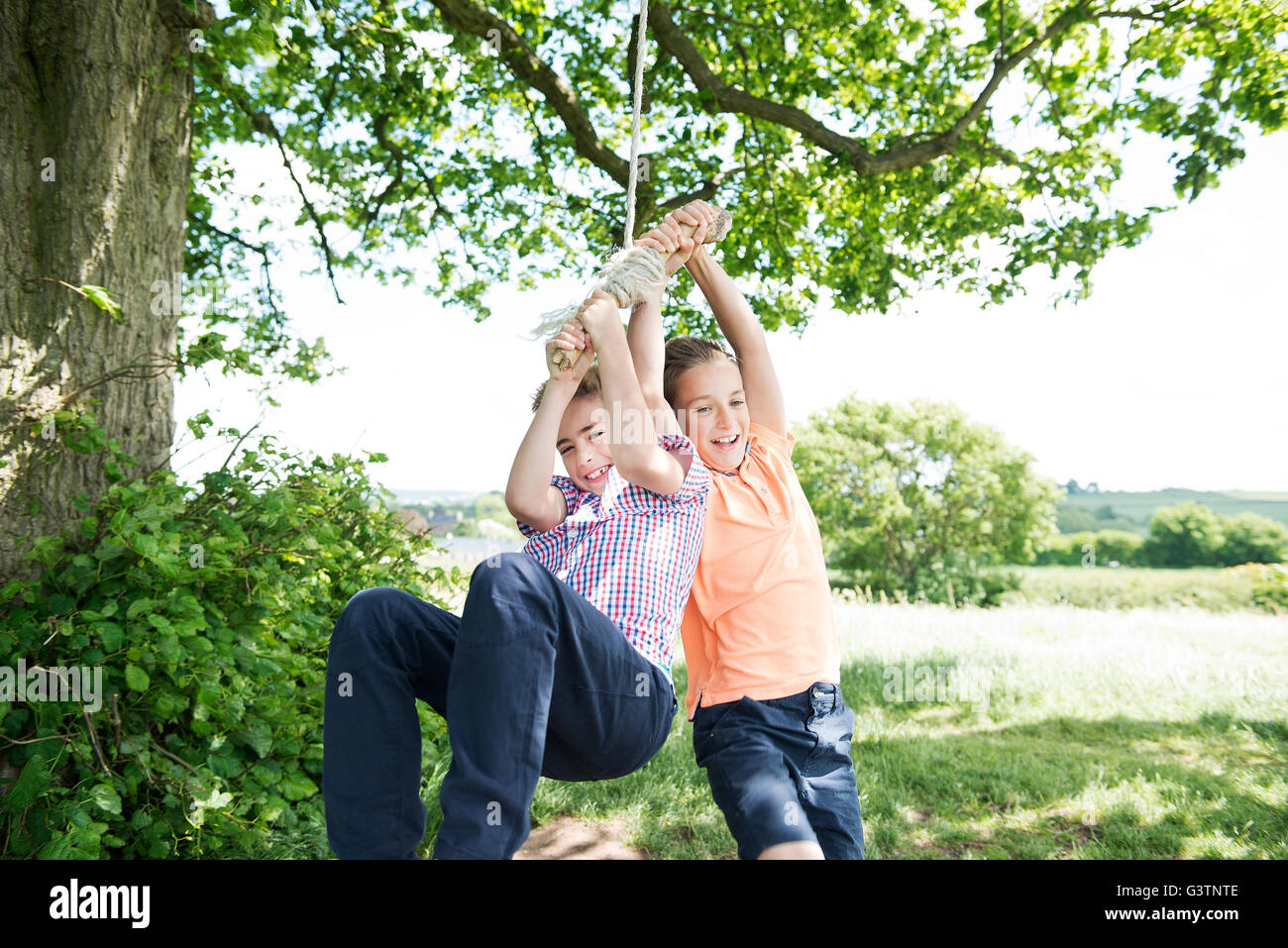 Two boys playing on a swing hi-res stock photography and images - Alamy