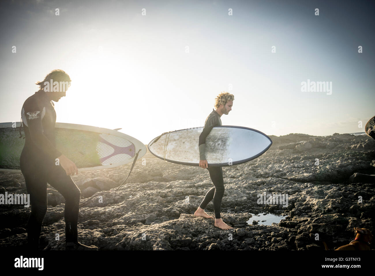 Two men preparing to surf at Corralejo in Fuerteventura Stock Photo - Alamy