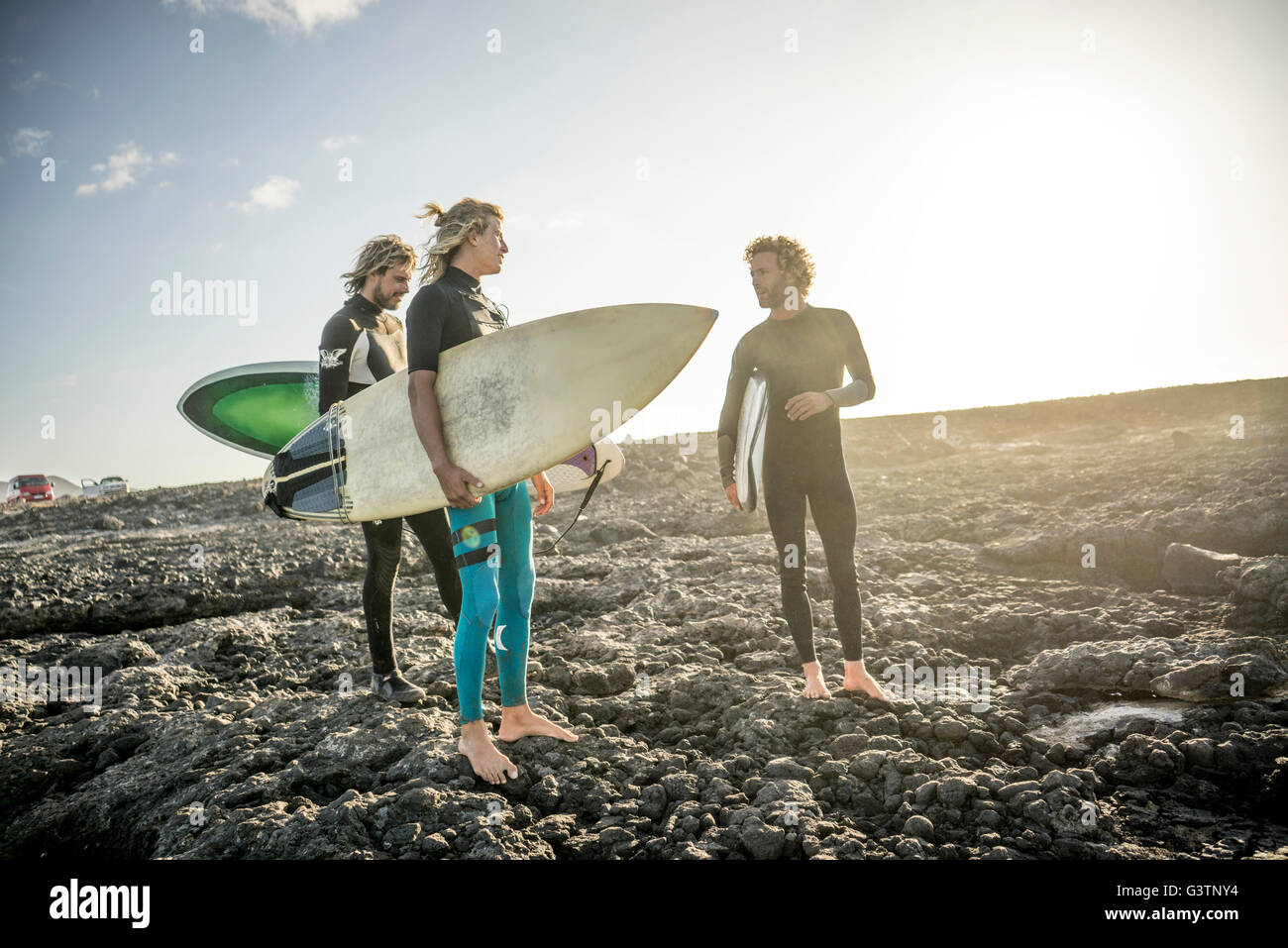 Three men preparing to surf at Corralejo in Fuerteventura Stock Photo ...