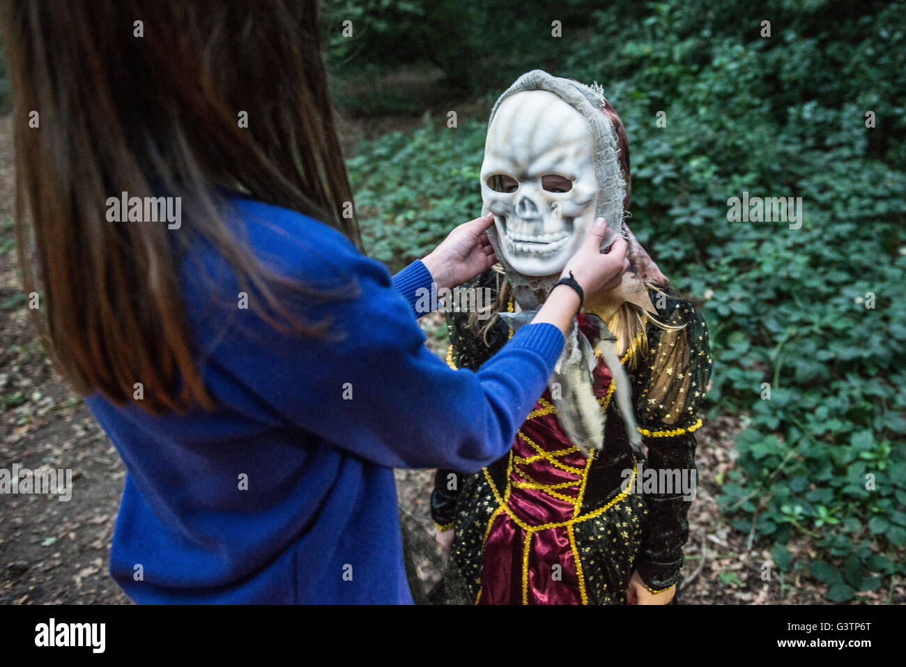 A girl helping her friend with her costume for Halloween Night Stock ...