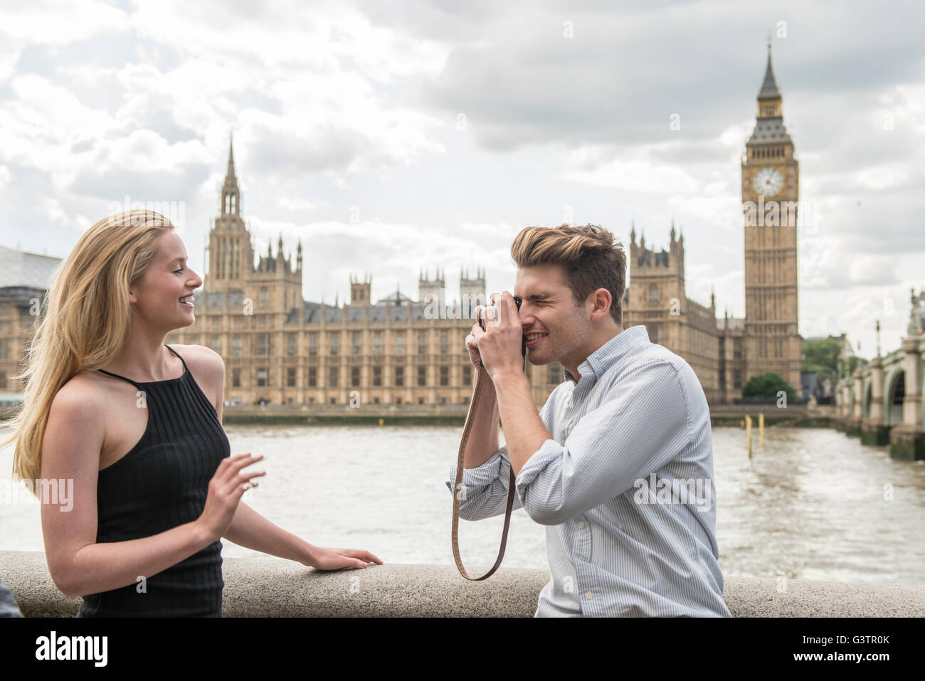 Two friends taking photographs on the South Bank in London with the ...